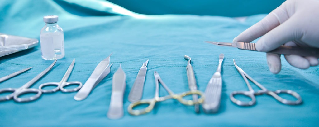 Hand holding surgical instruments | Elmed